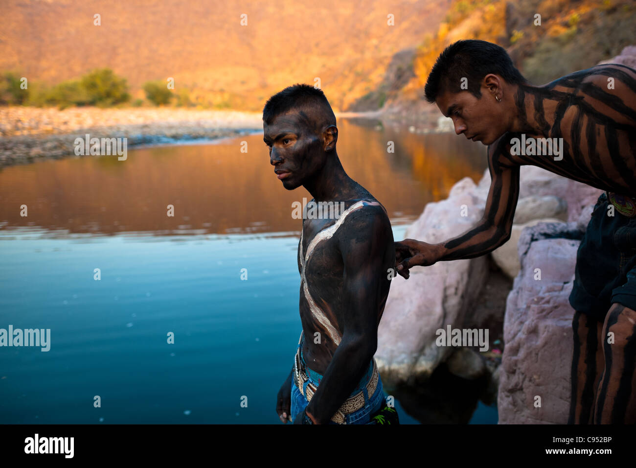 A Cora Indian boy, being painted by his mate, prepares himself for the ...