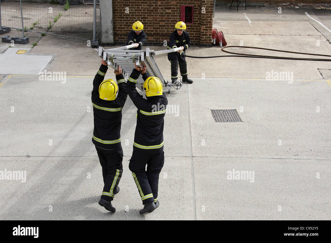 Firefighters carrying a ladder during a training exercise Stock Photo ...