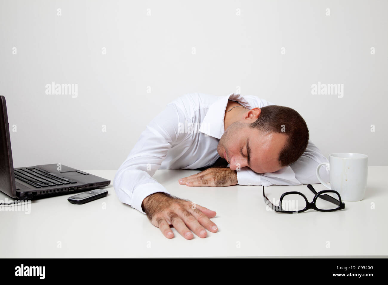 Man resting head on table Stock Photo - Alamy