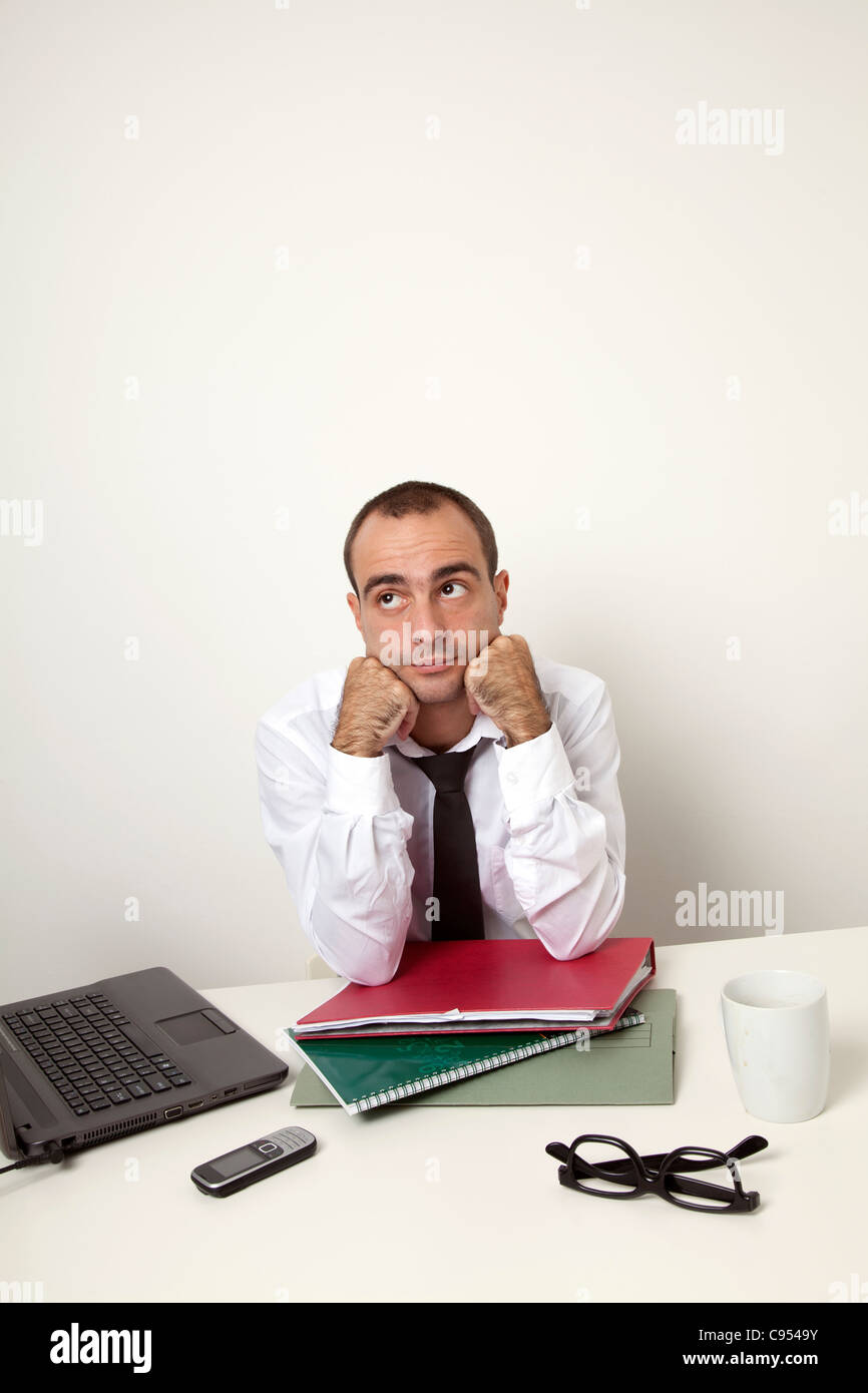 Bored man at work desk Stock Photo - Alamy