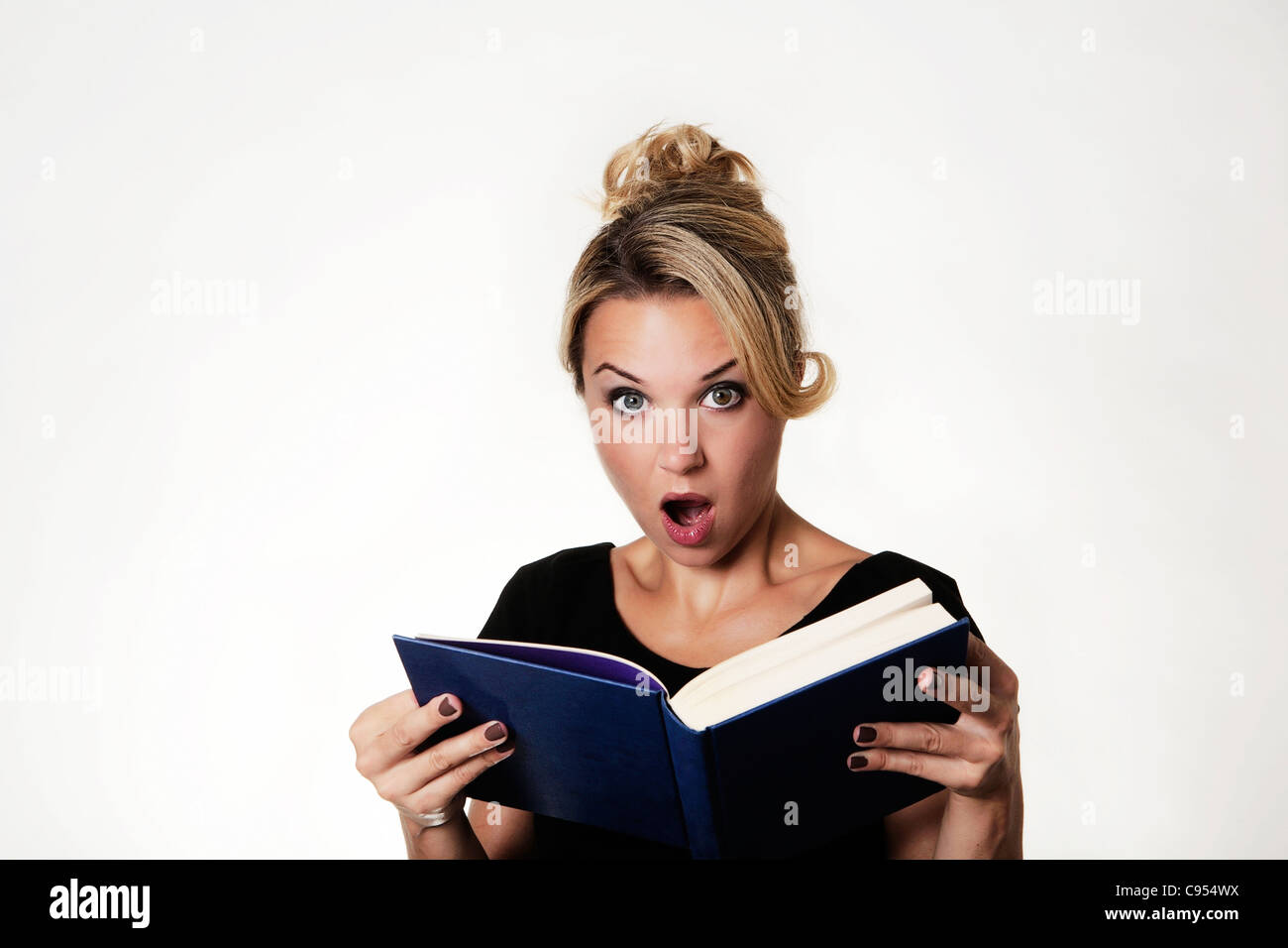 Girl looking surprised reading book hi-res stock photography and images ...