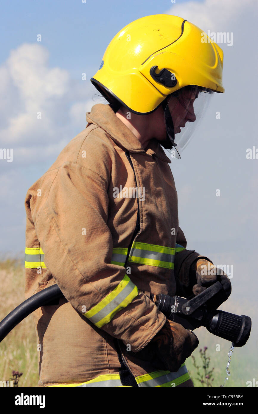 Female Firefighter with a hose Stock Photo - Alamy