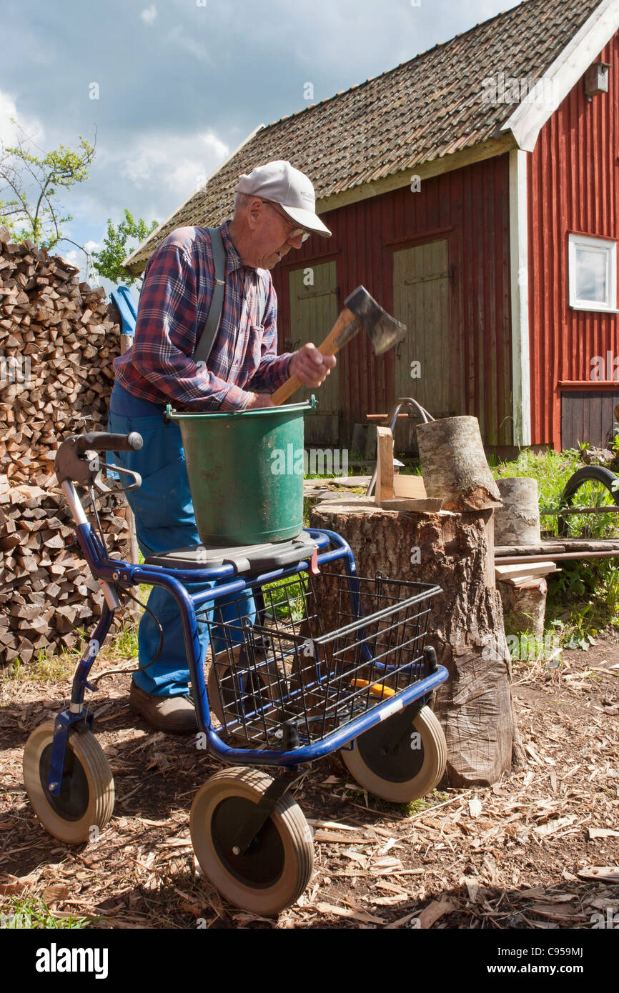 An old man chopping wood with a rollator Stock Photo - Alamy
