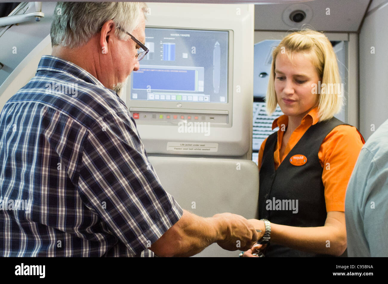 Man presenting boarding pass to stewardess while boarding an easyJet ...