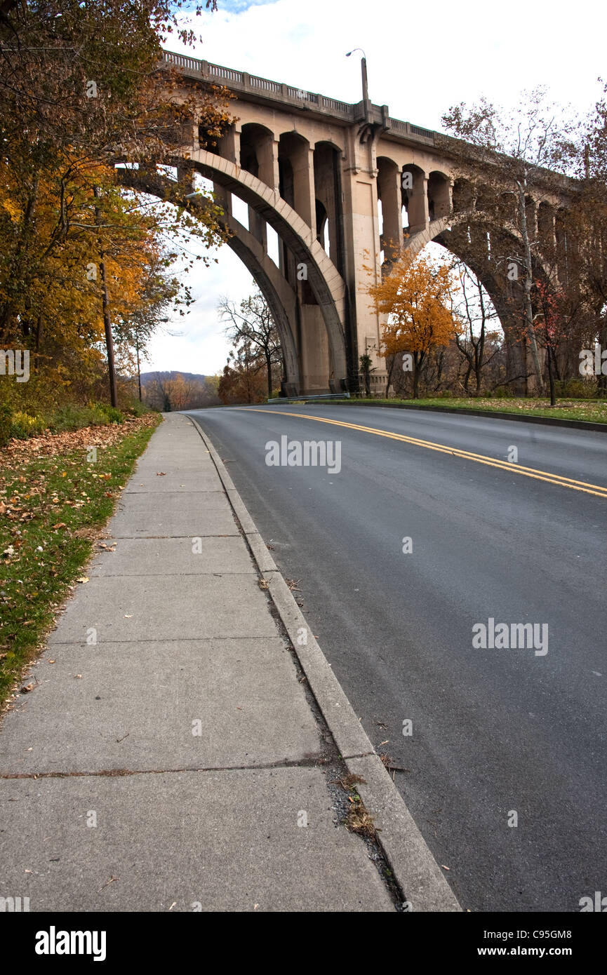 City street running under arched bridge Stock Photo - Alamy