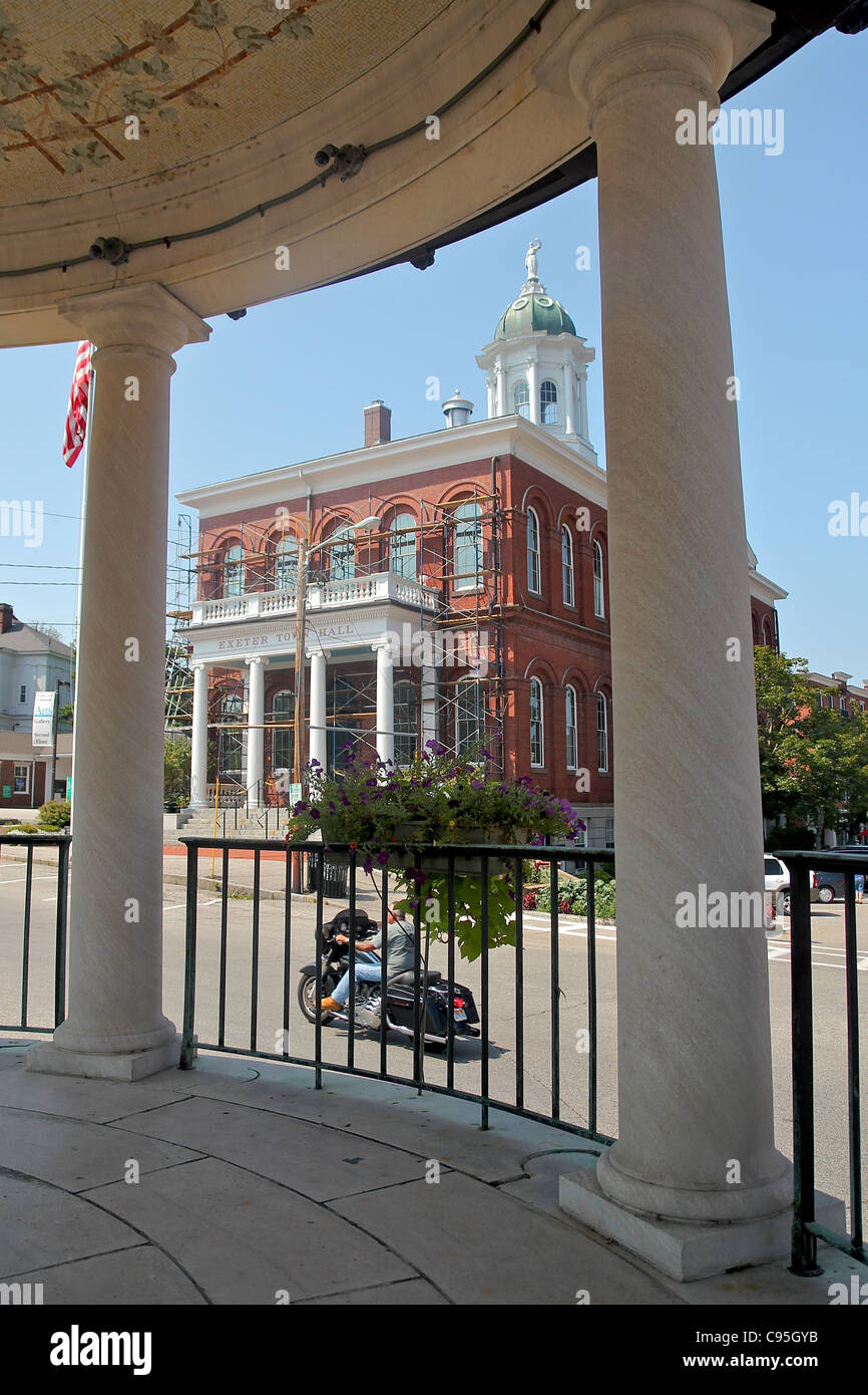 Town Hall and motorcyclist, seen between columns of the bandstand ...