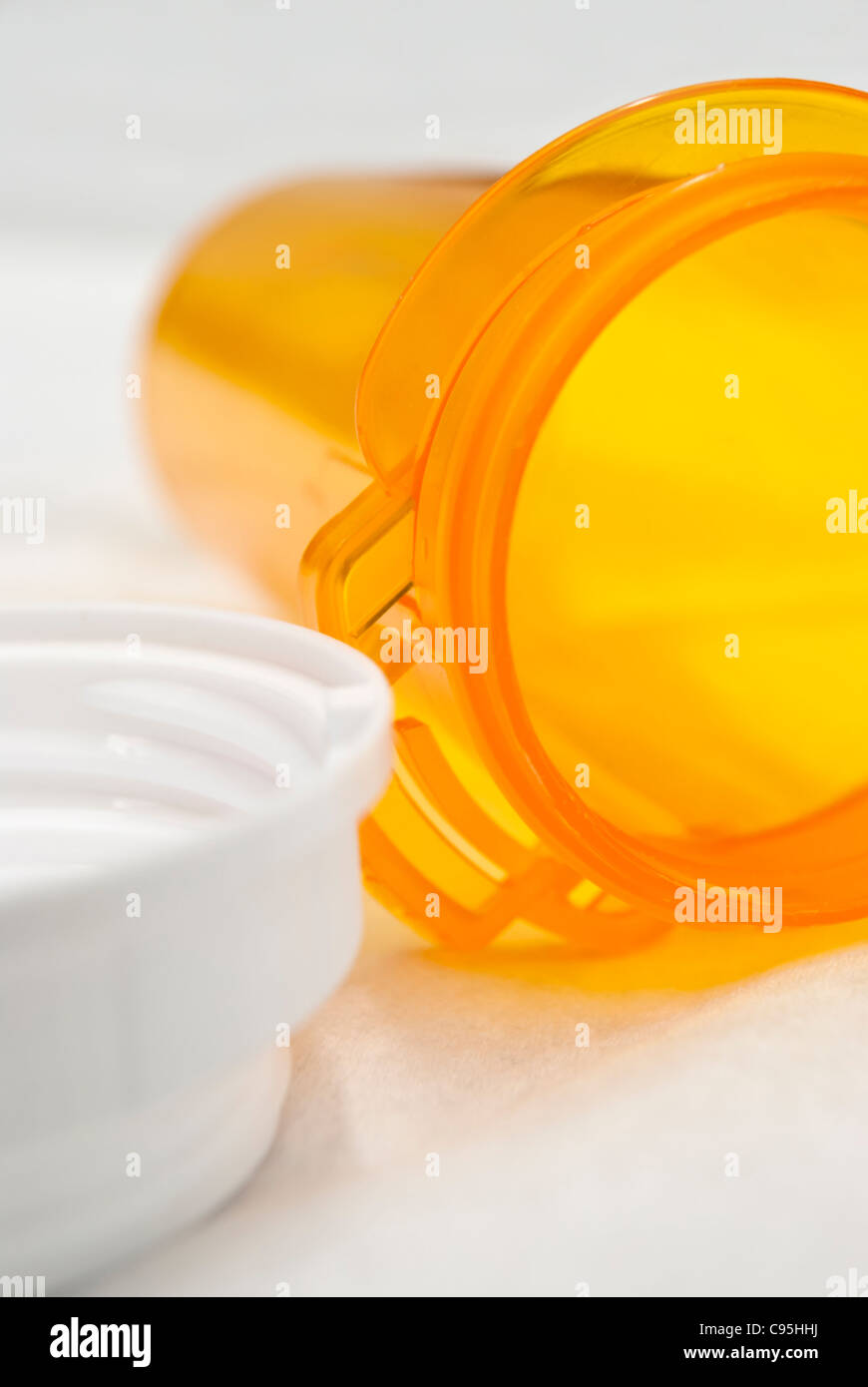 Child safe pill bottle open on a table with child safe lid nearby Stock ...