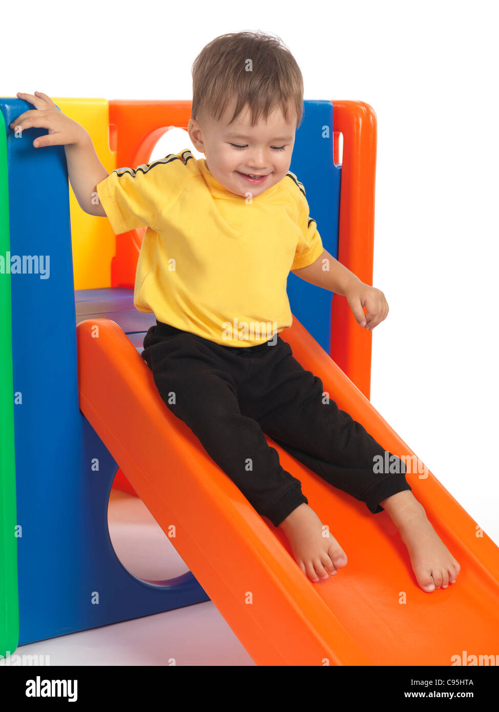 Happy one and a half year old child on a slide. Isolated on white ...