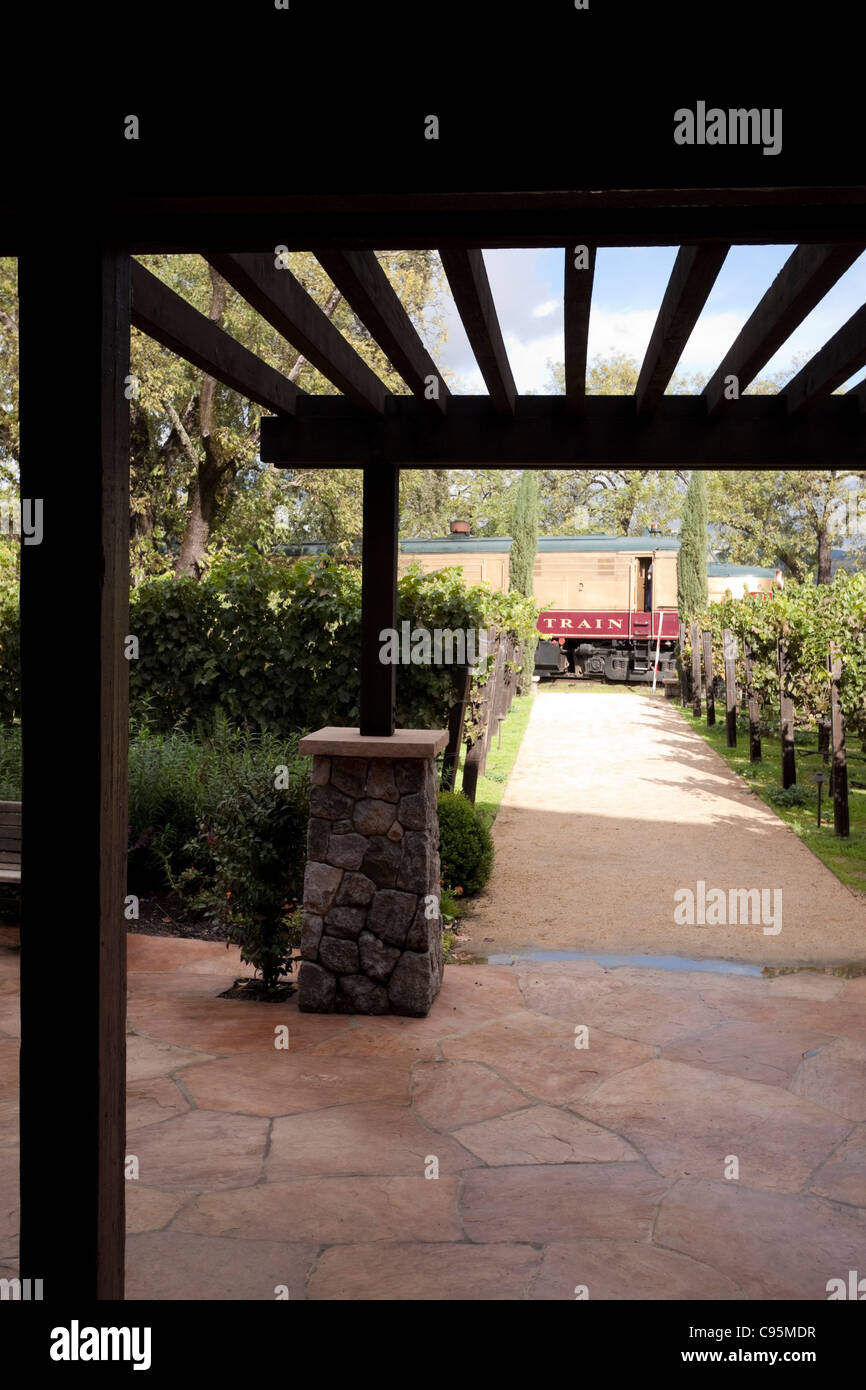 A trellis framing a beautiful landscaped view of a train in the ...