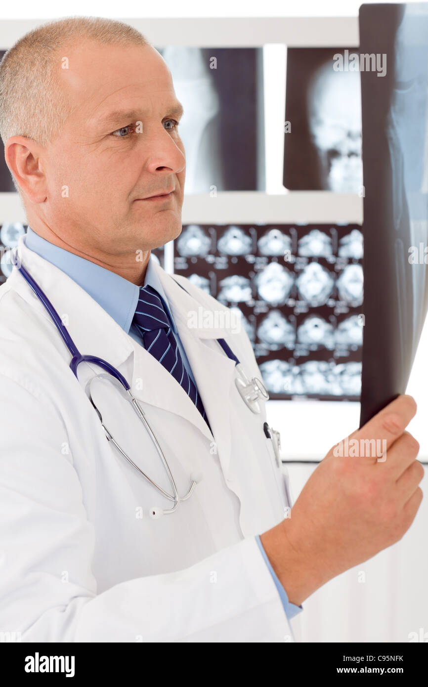 Male doctor standing at front of set x-ray looking Stock Photo - Alamy