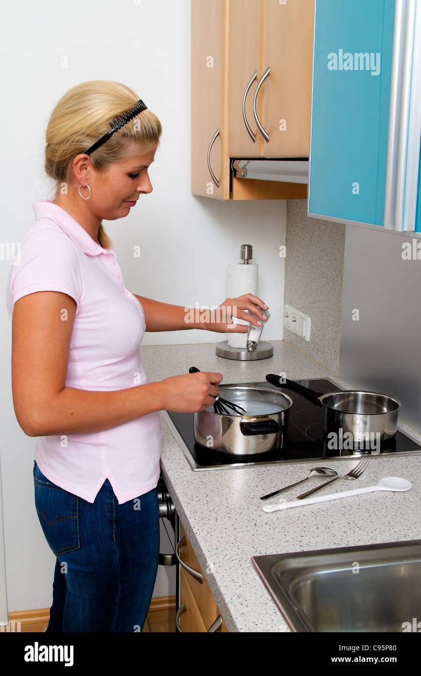 A woman in the kitchen while cooking with electric stove Stock Photo ...