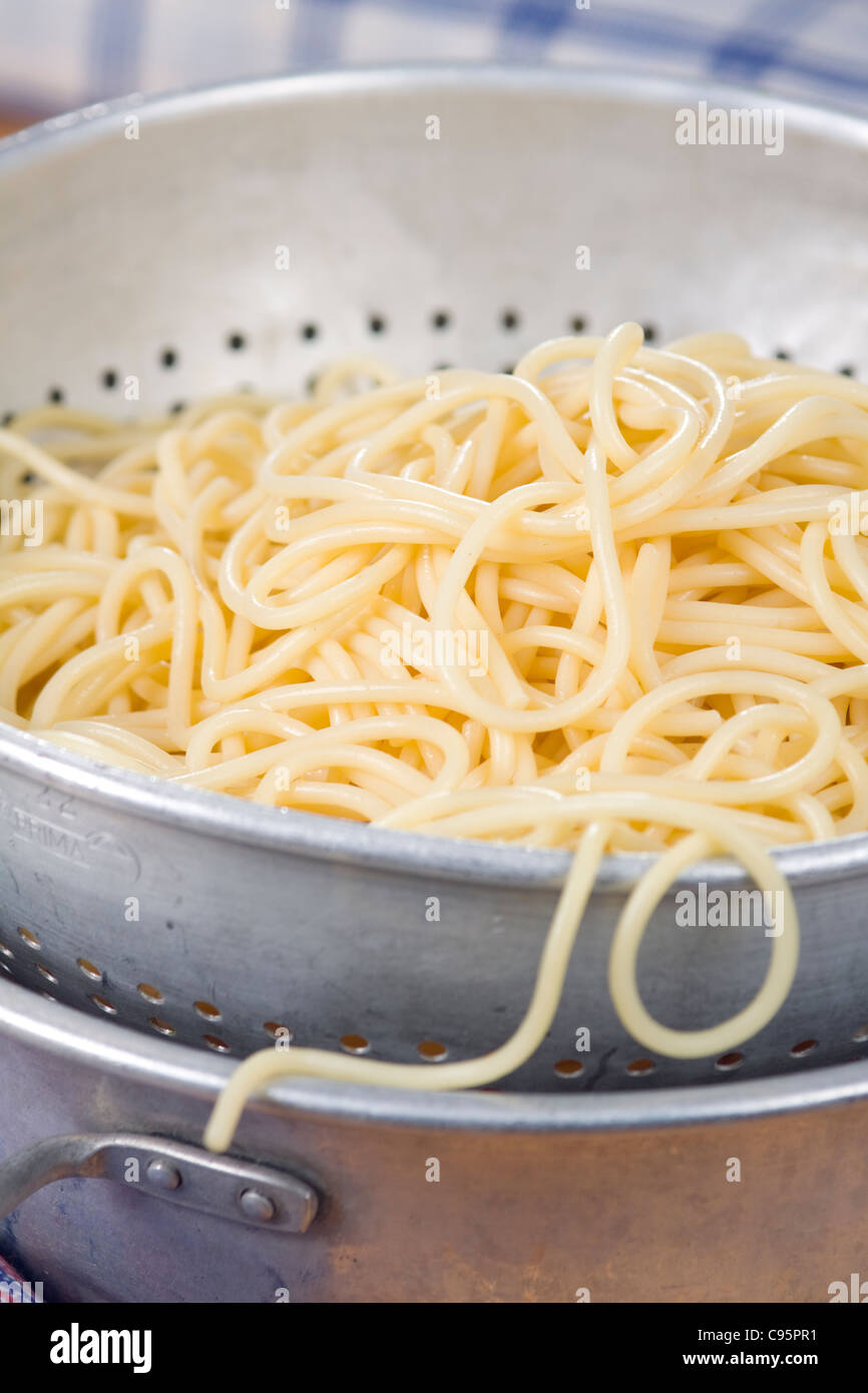 Spaghetti in a tin plate sieve dripping Stock Photo - Alamy