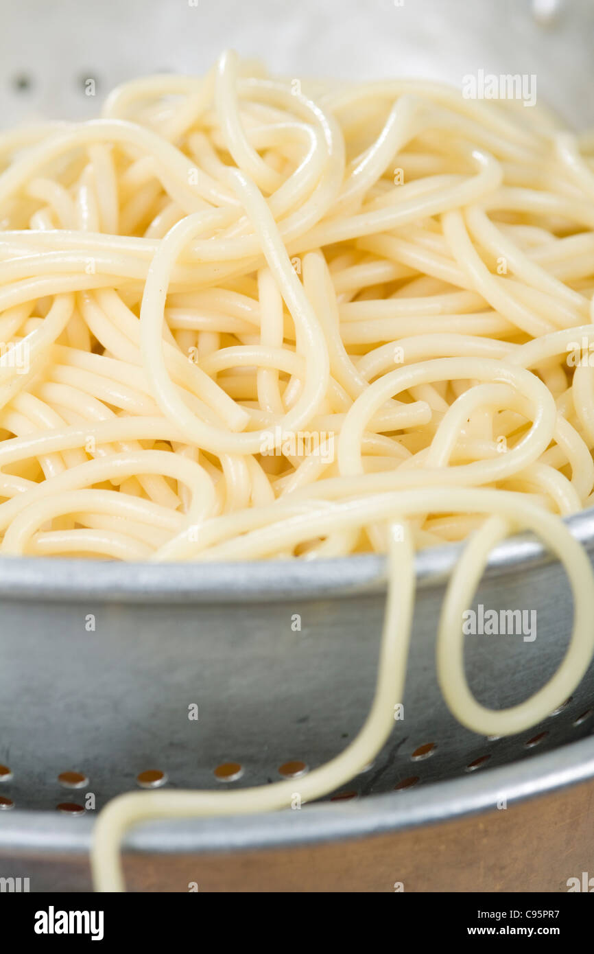 Spaghetti in a tin plate sieve dripping Stock Photo - Alamy