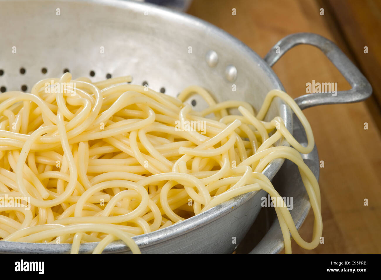 Spaghetti in a tin plate sieve dripping Stock Photo - Alamy