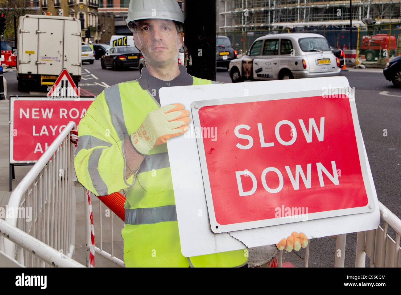 Cut out image of a road worker in a fluorescent yellow jacket holding a ...
