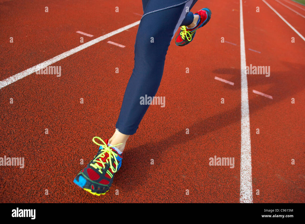 Running. Close-up of the legs of a woman running on an athletics track ...