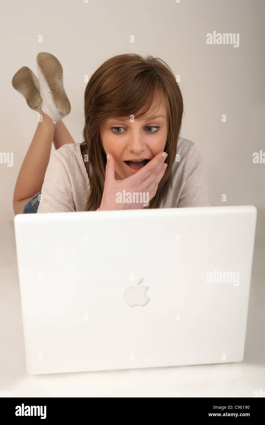 Teenage girl looking shocked using a laptop Stock Photo - Alamy