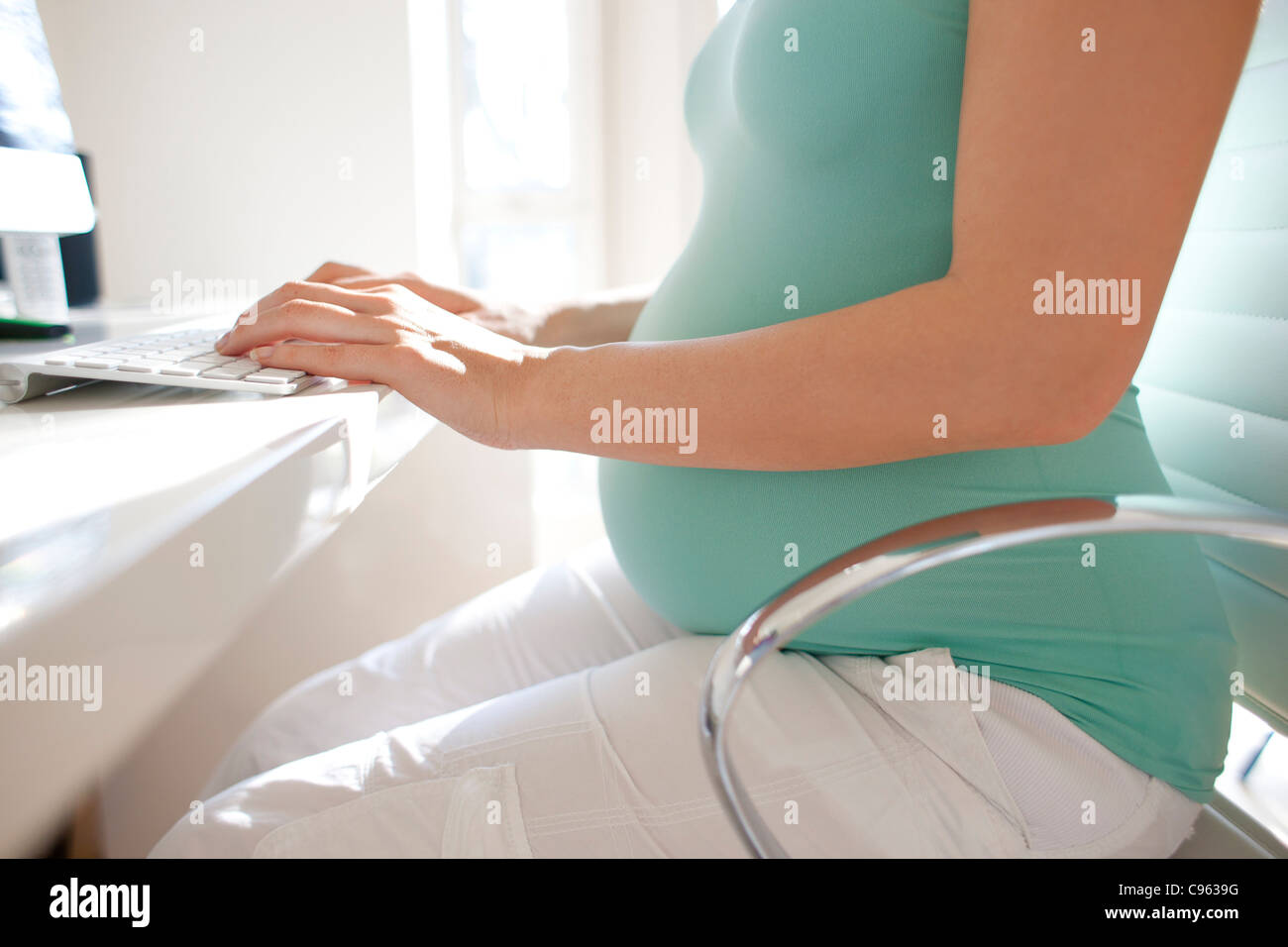 Pregnant woman using a computer Stock Photo - Alamy