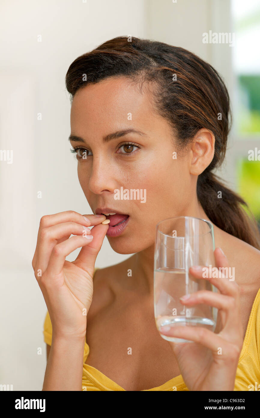 Woman taking a pill Stock Photo - Alamy