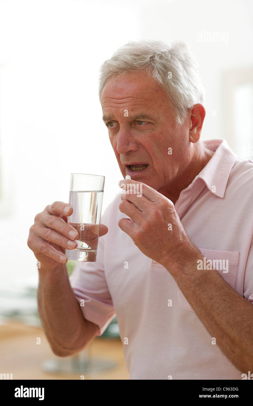 Man taking a pill Stock Photo - Alamy