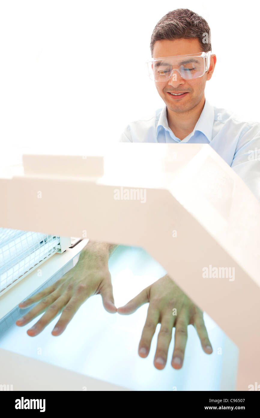 Phototherapy booth. Patient with their hands in a phototherapy box ...