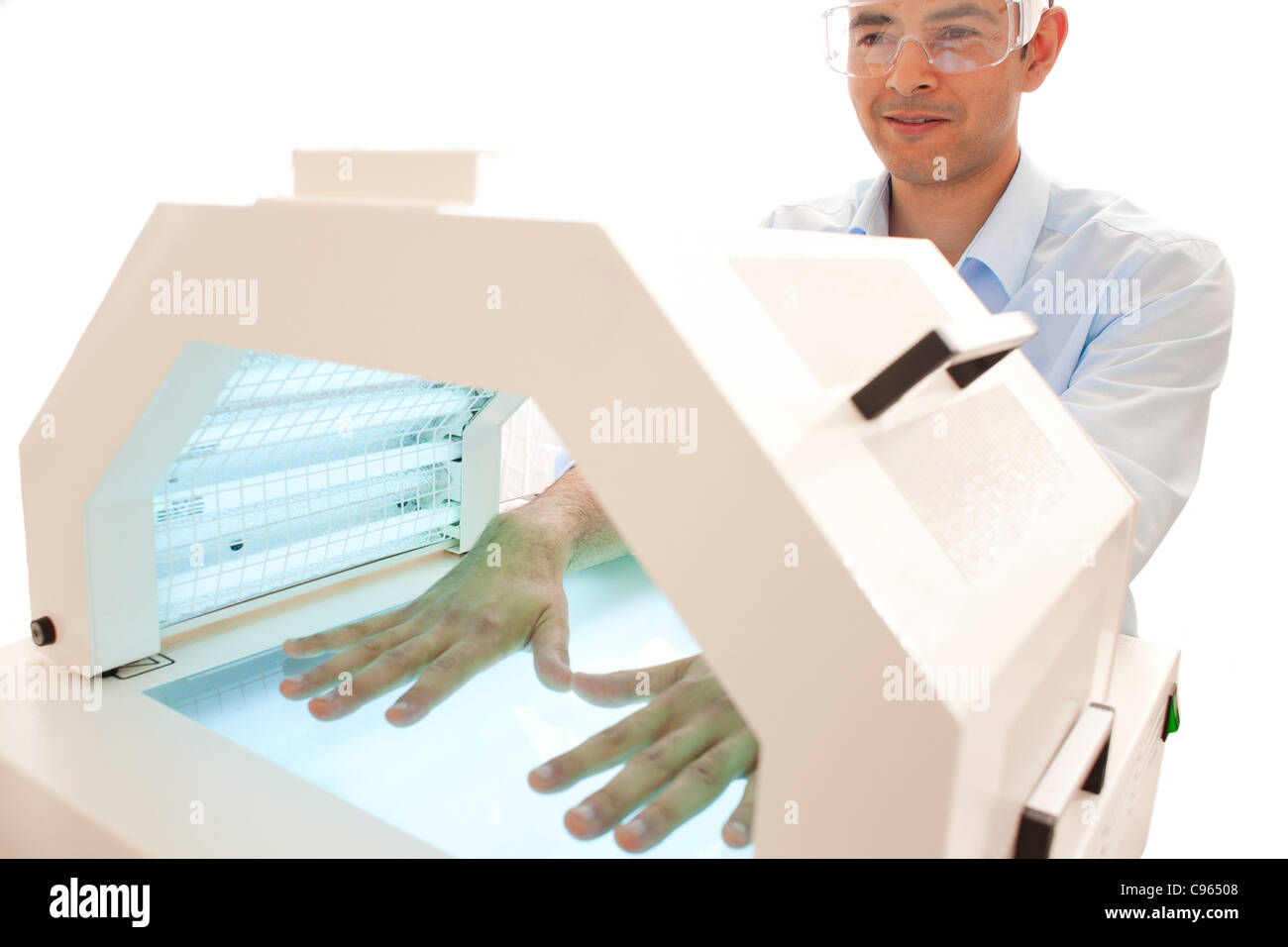 Phototherapy booth. Patient with their hands in a phototherapy box ...