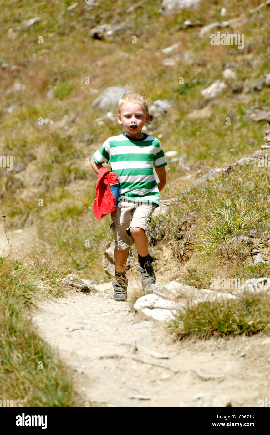 A young boy running along a mountain track Stock Photo - Alamy