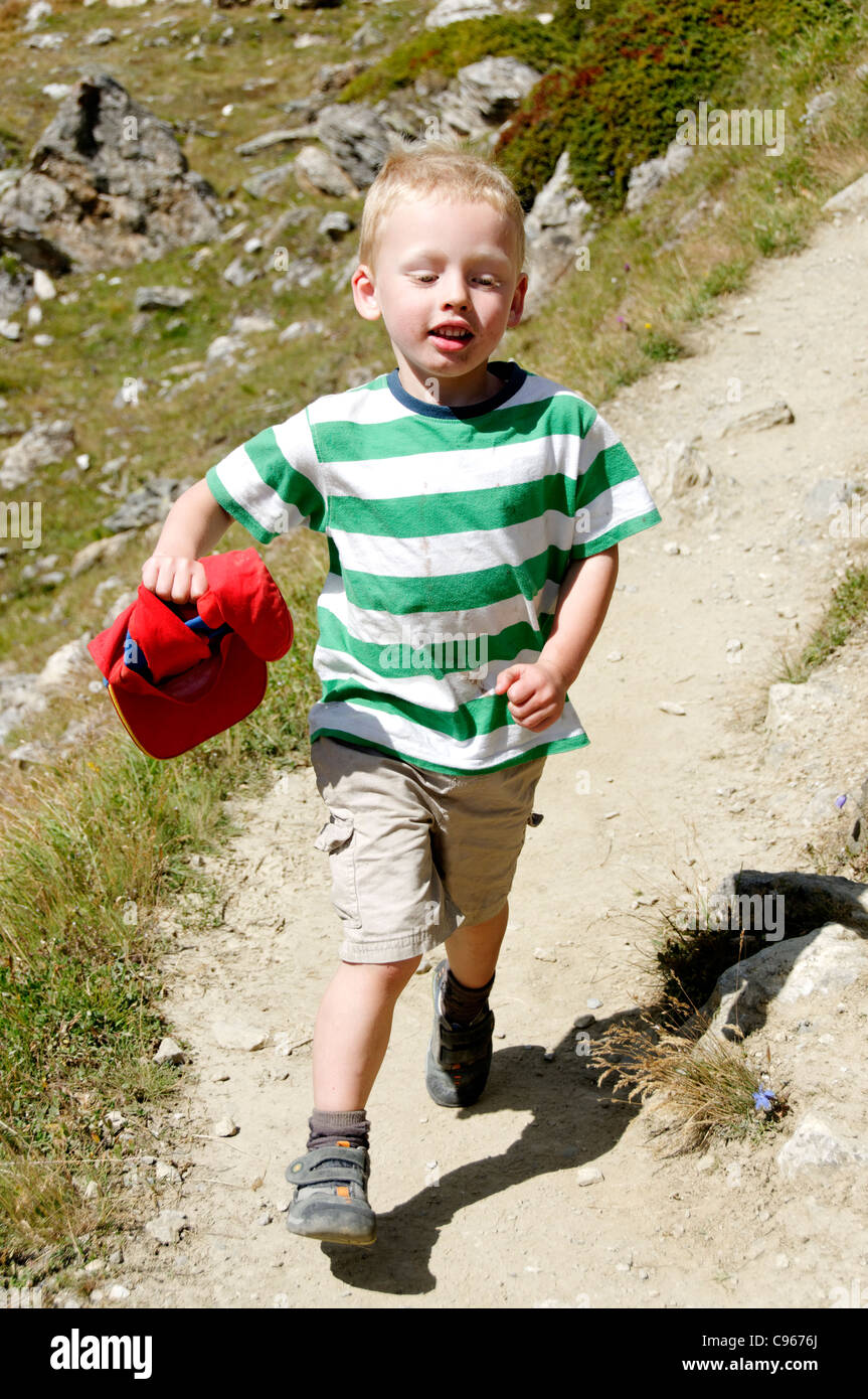 A young boy running along a mountain track Stock Photo - Alamy