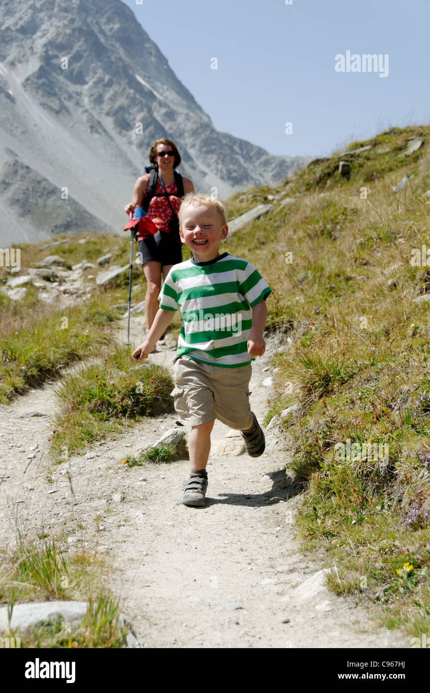 A young boy running along a mountain track Stock Photo - Alamy