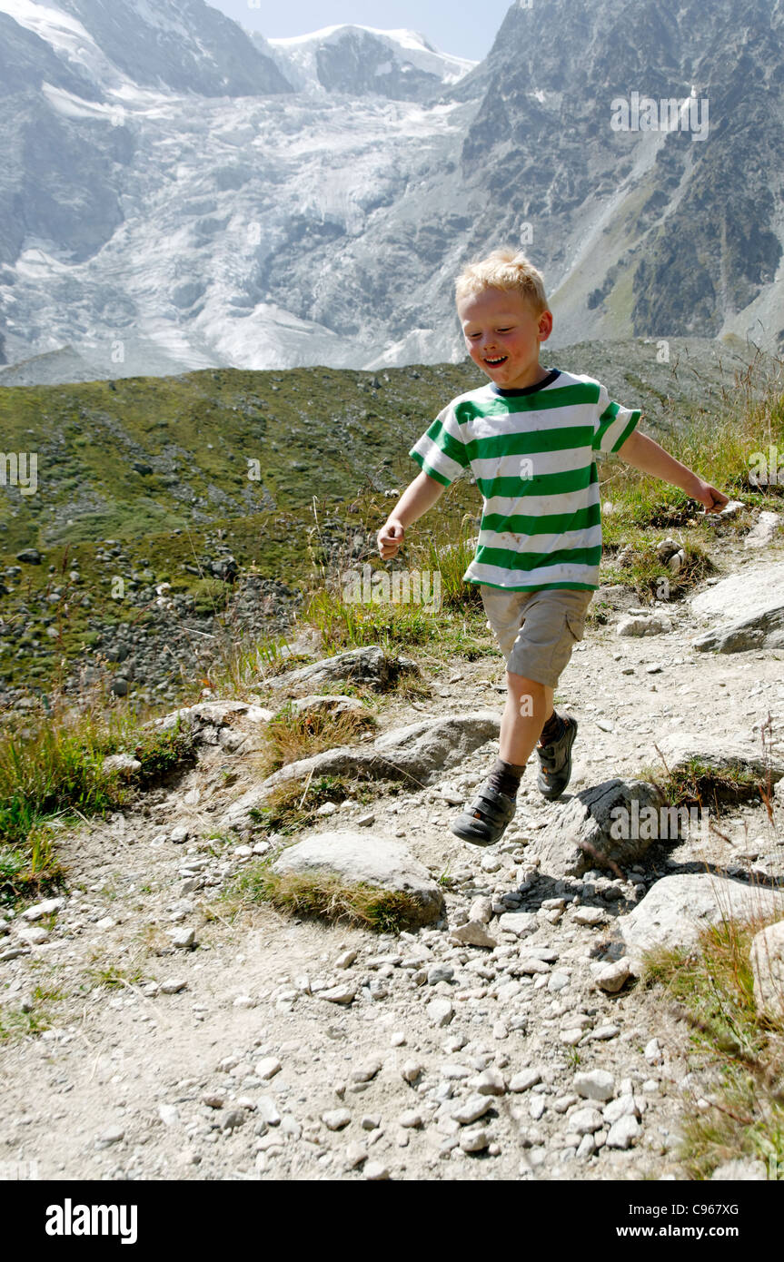 A young boy running along a mountain track Stock Photo - Alamy