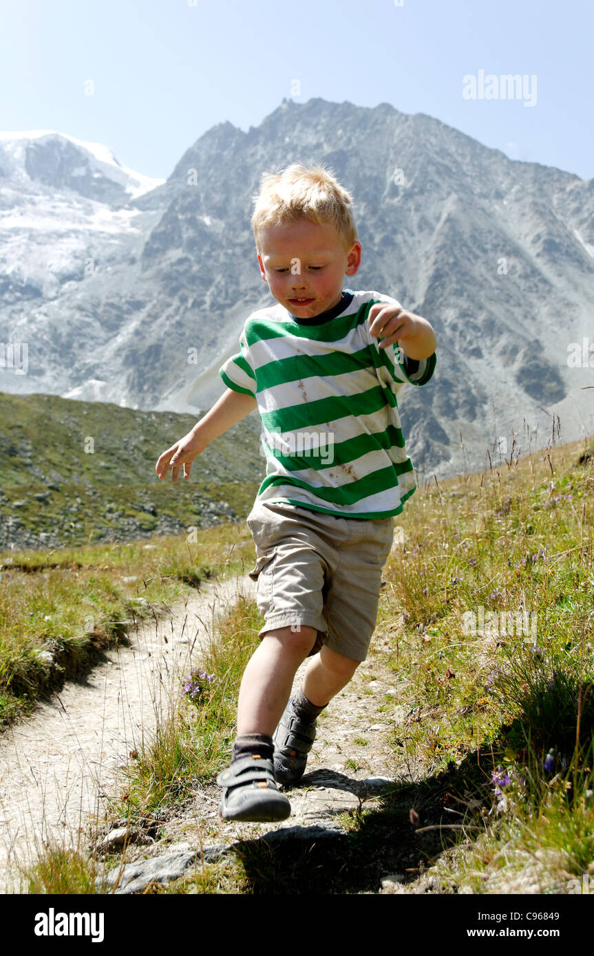 A young boy running along a mountain track Stock Photo - Alamy