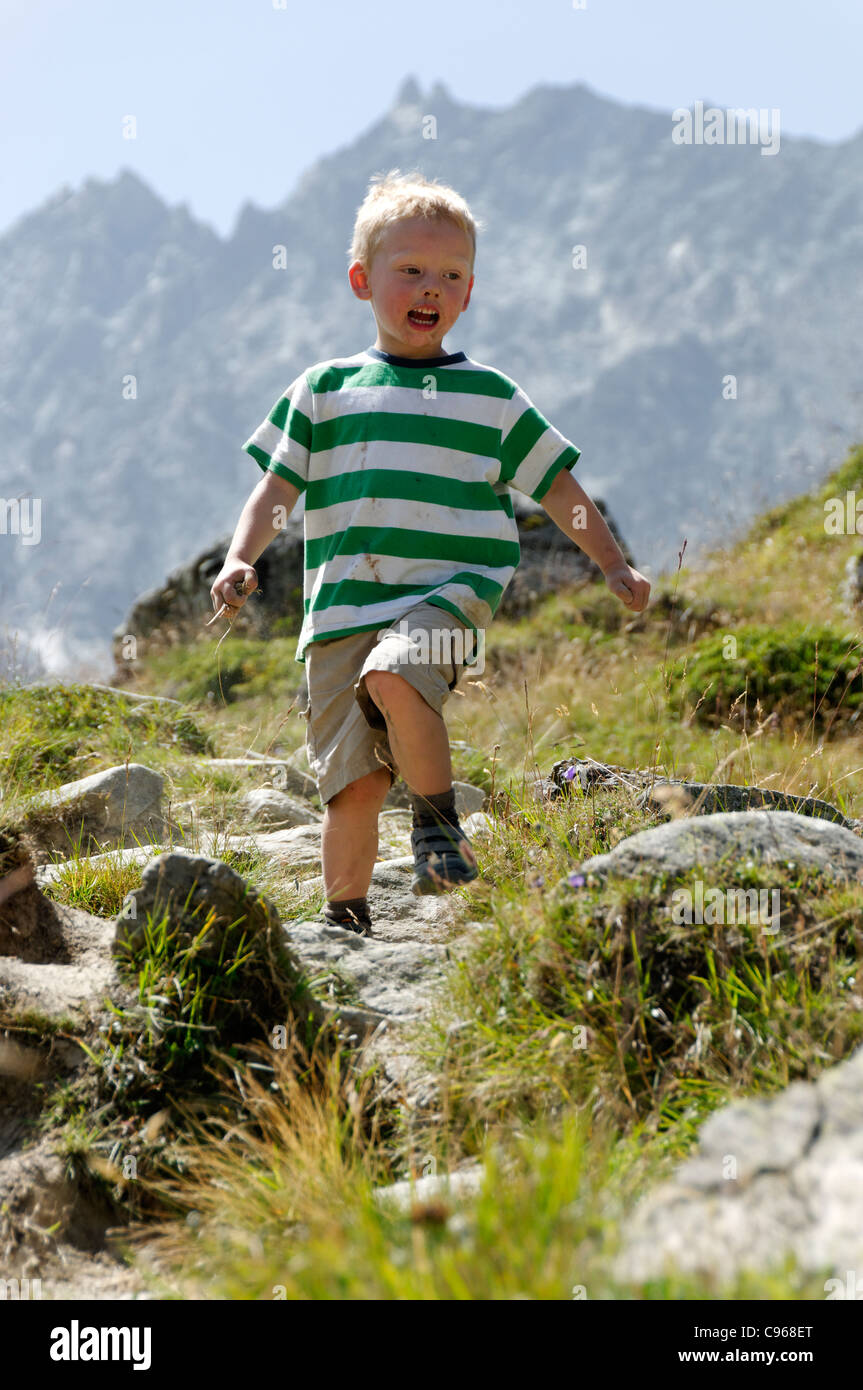 A young boy running along a mountain track Stock Photo - Alamy