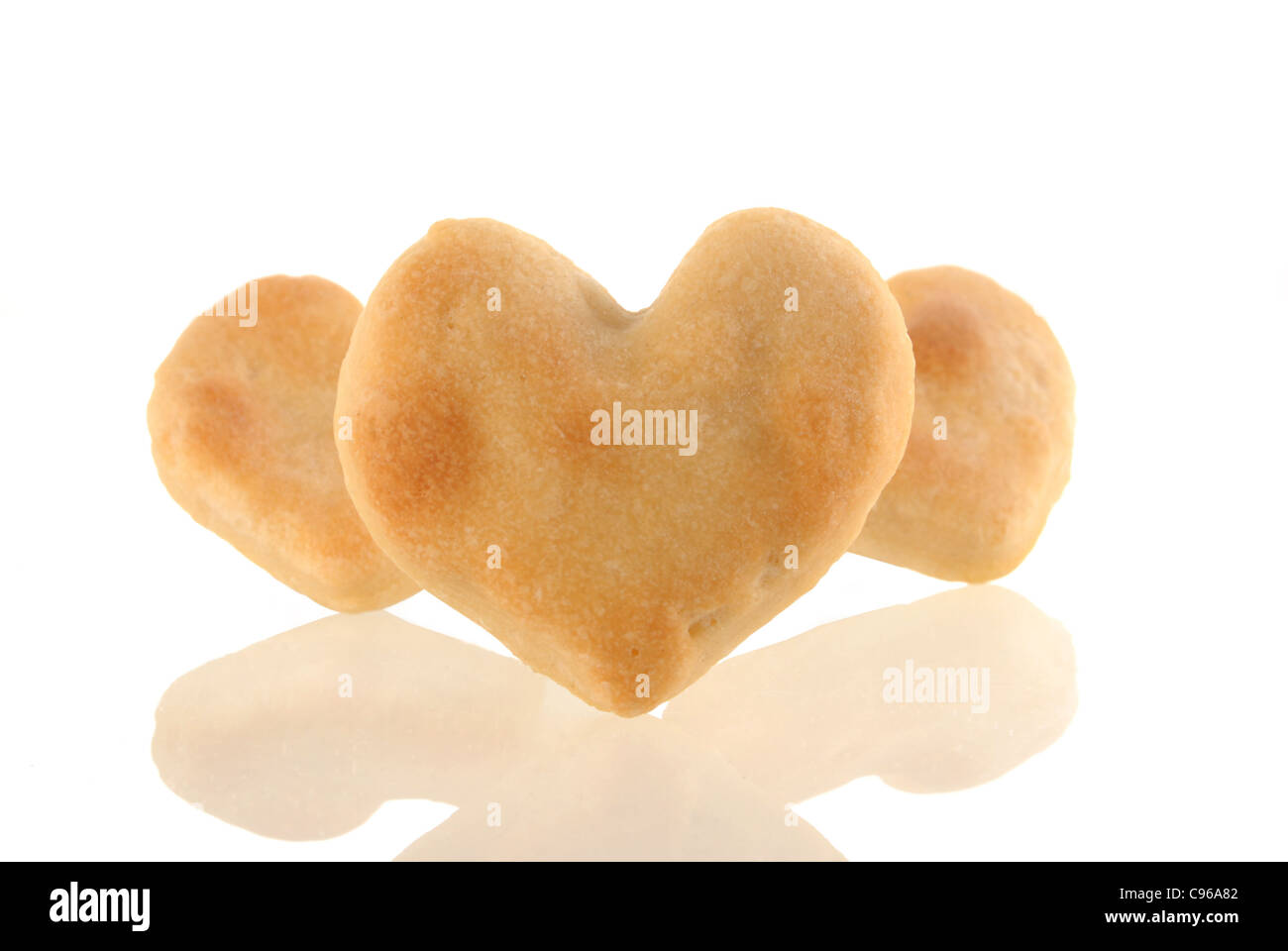 Three heart-shaped cookies isolated and its reflection on white ...