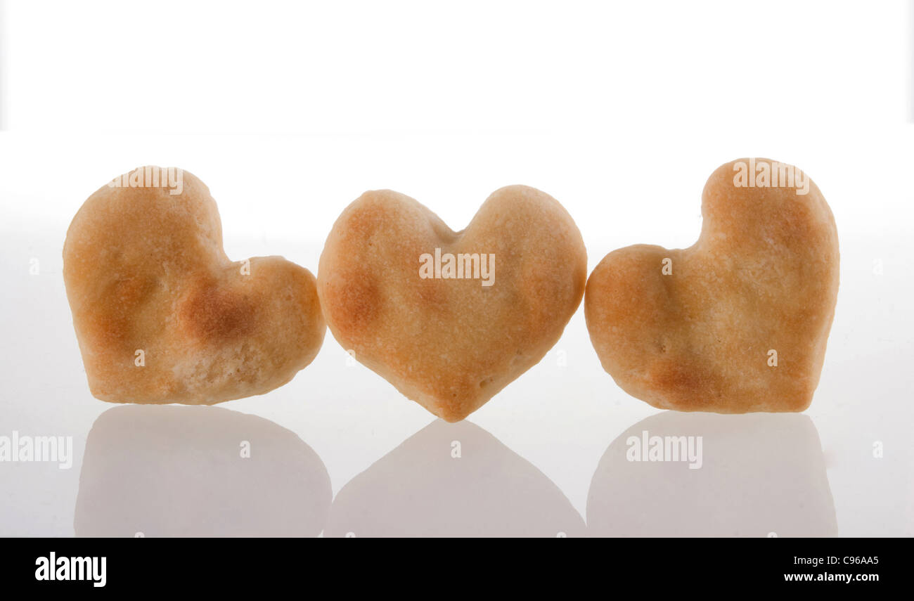 Three heart-shaped cookies isolated and its reflection on white ...