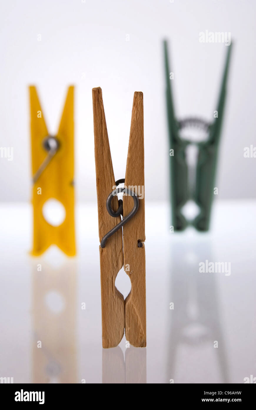 Three clothes peg composition with its reflection on white background ...