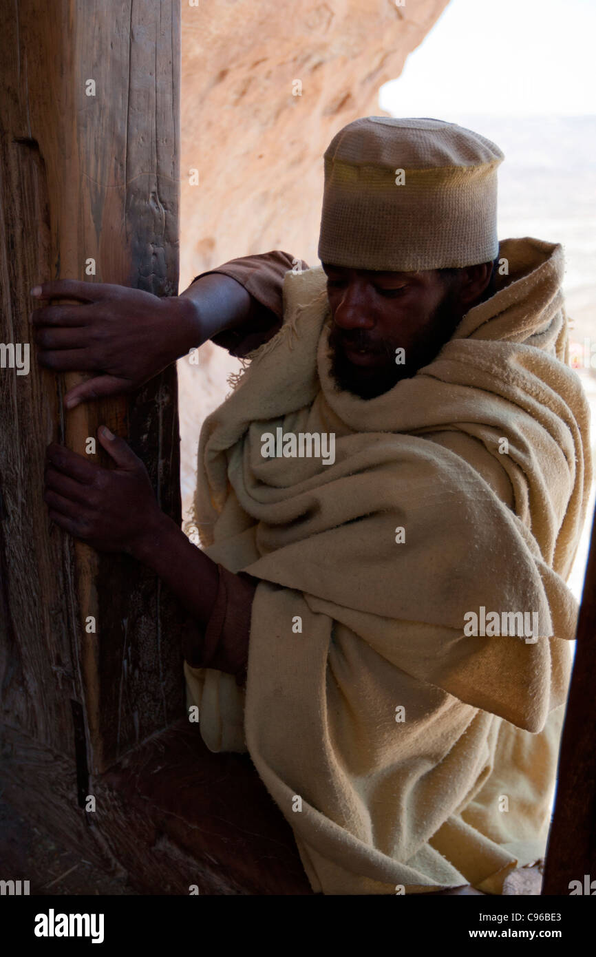 An Orthodox Christian priest climbs up to the cliff-top monastery Debre ...