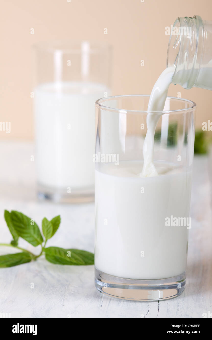 A glass is filled from a bottle of milk Stock Photo - Alamy
