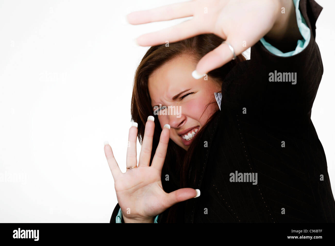 woman with her arm up looking scared as if somethings going to hit her ...