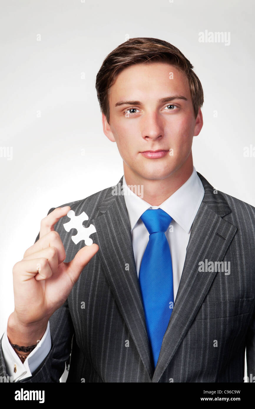 business man holding a jigsaw piece in his hand Stock Photo - Alamy