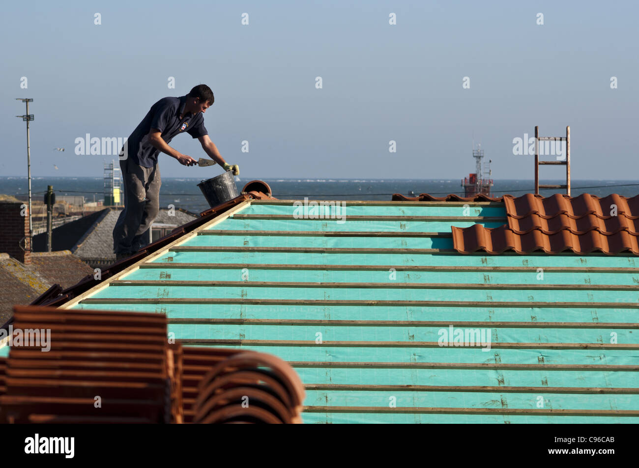 Builder roofer working on roof Stock Photo - Alamy
