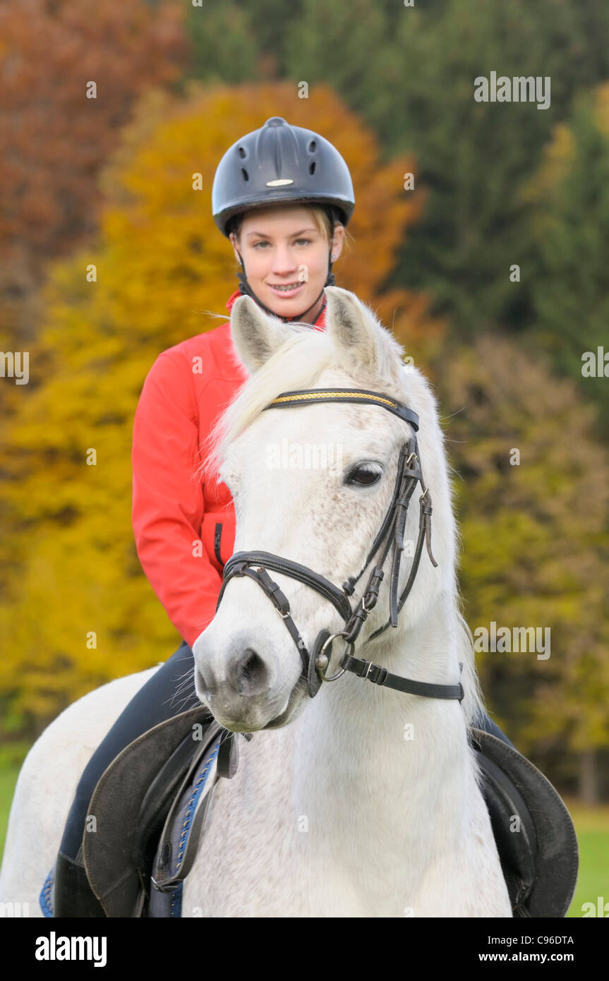 Young rider on white pony in autumn Stock Photo - Alamy