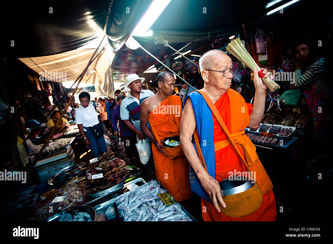 Monks collecting alms at Maeklong Market - Thailand Stock Photo - Alamy