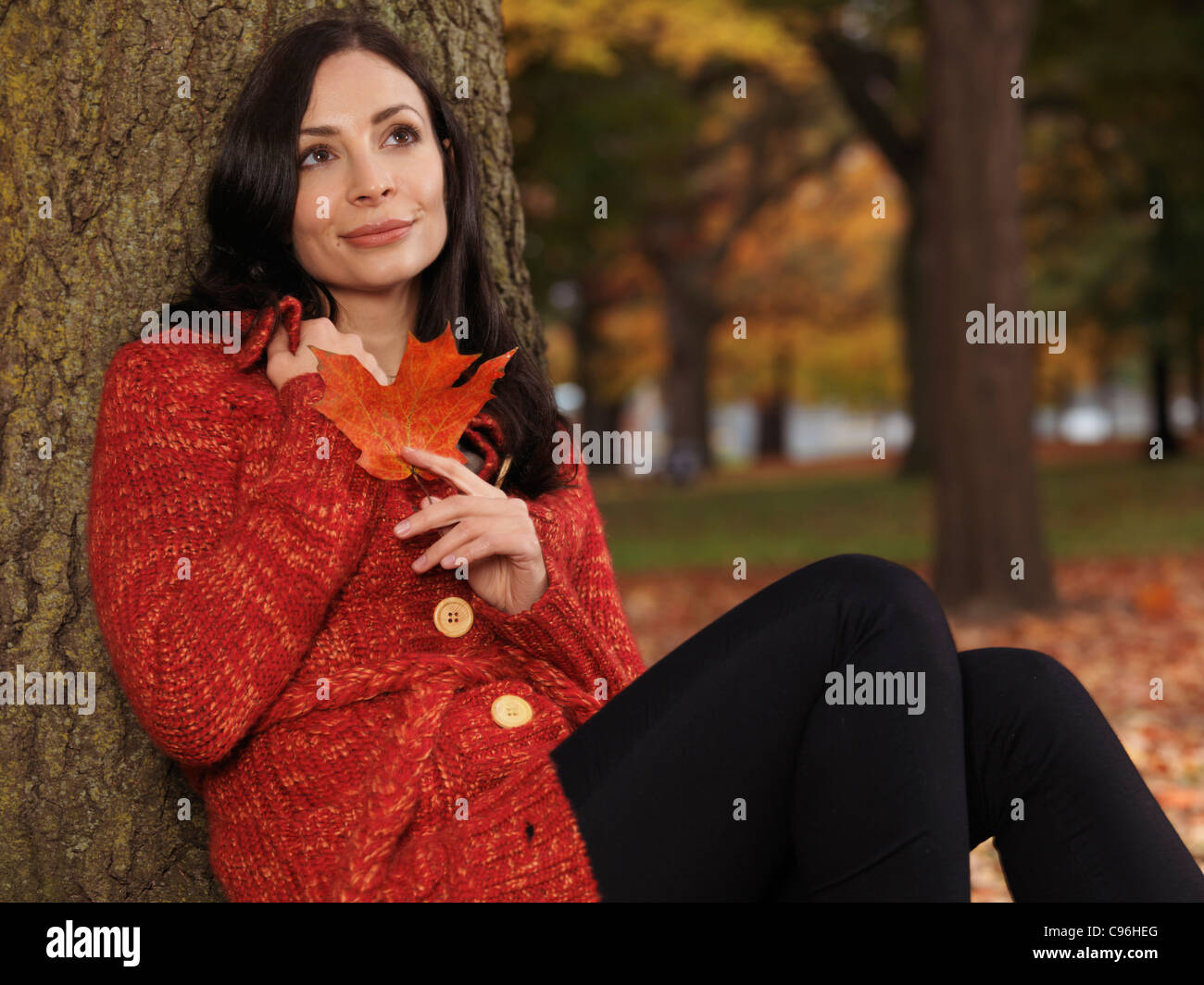 Beautiful smiling woman with daydreaming expression cuddling up in a ...