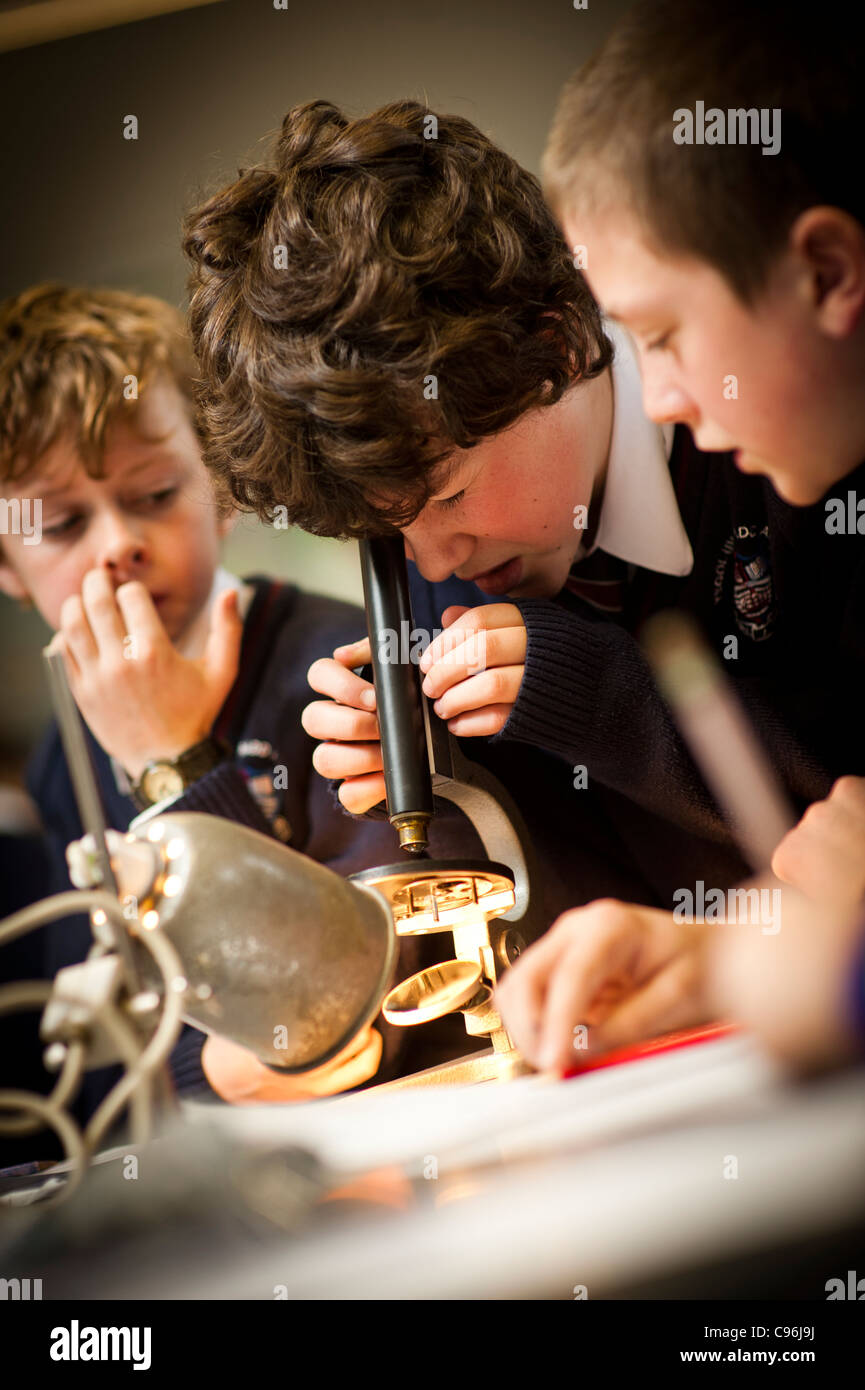 Secondary school children looking through a microscope in a science ...