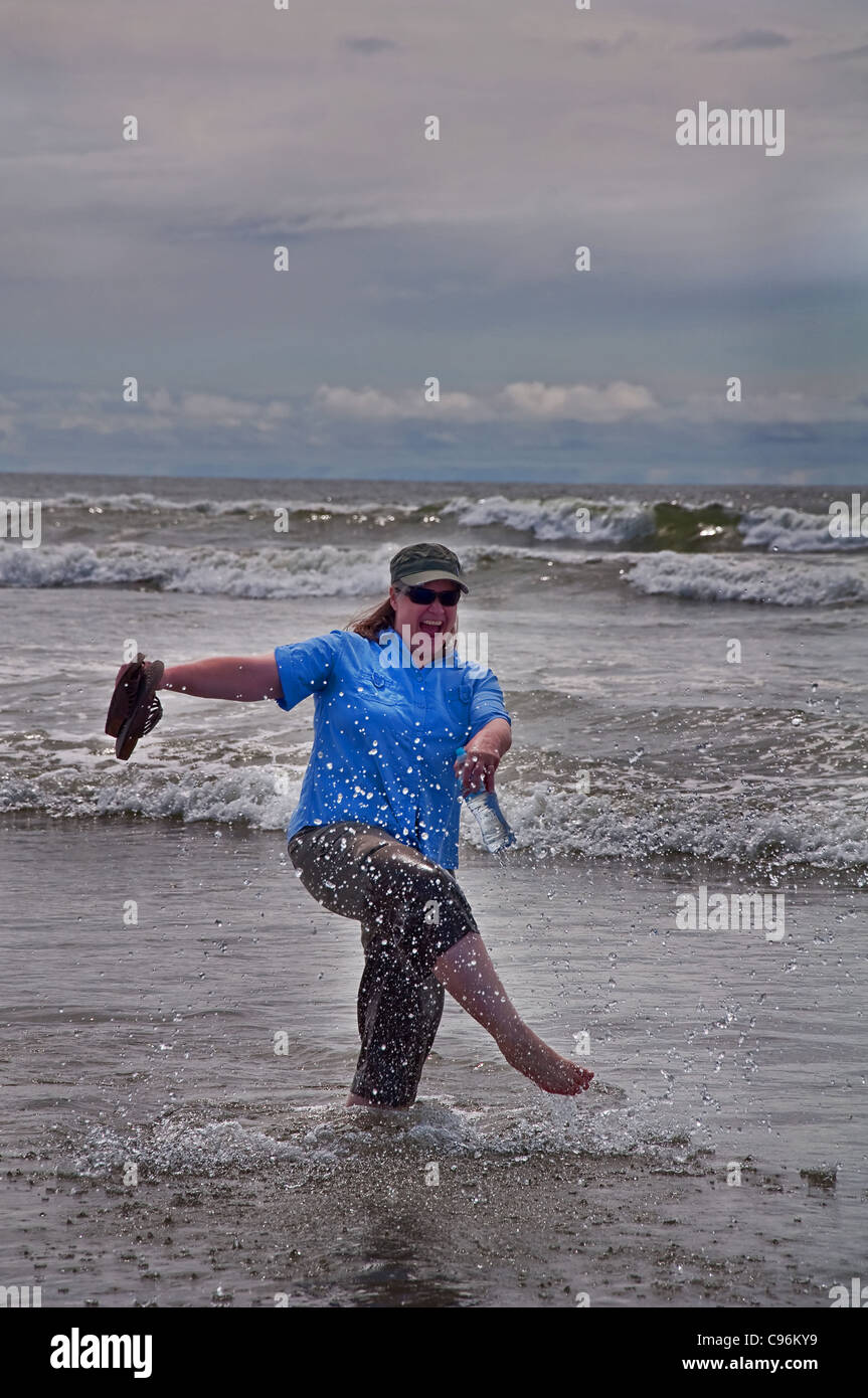 This vertical stock image shows a Caucasian middle aged woman laughing ...