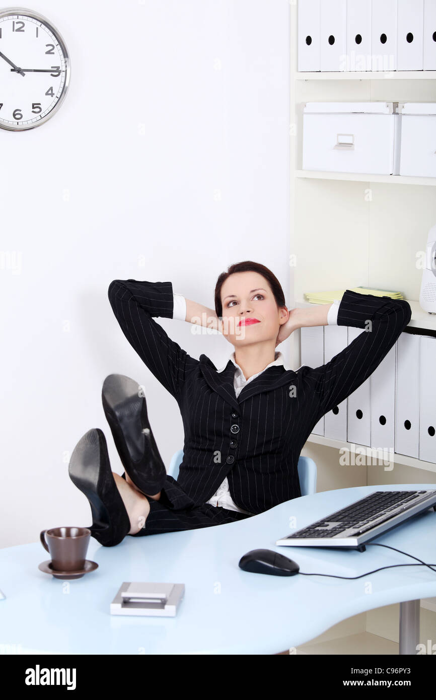 Pretty caucasian businesswoman with legs laying on the desk Stock Photo ...