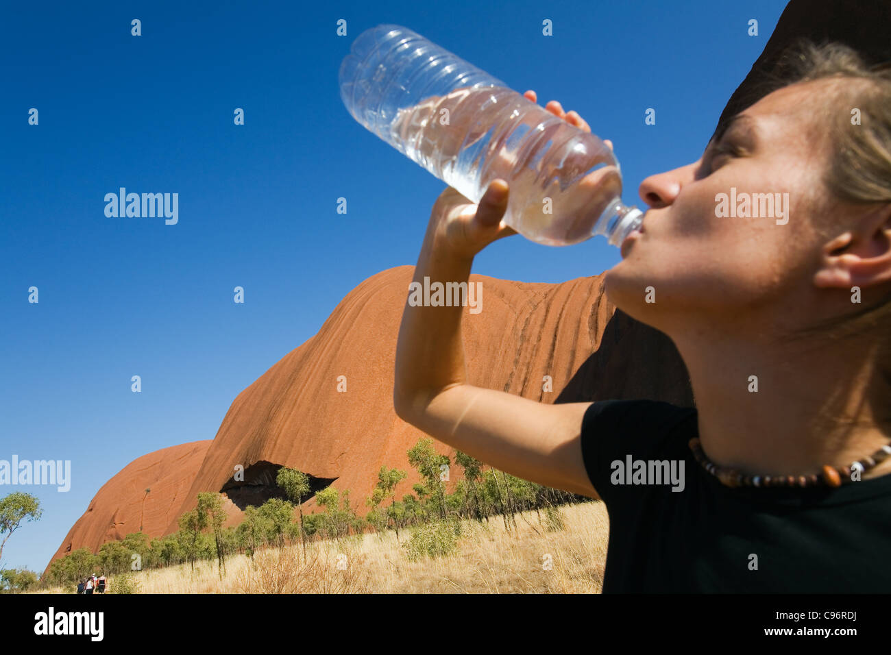 Hiker drinking water on the Uluru (Ayers Rock) Base Walk. Uluru-Kata ...