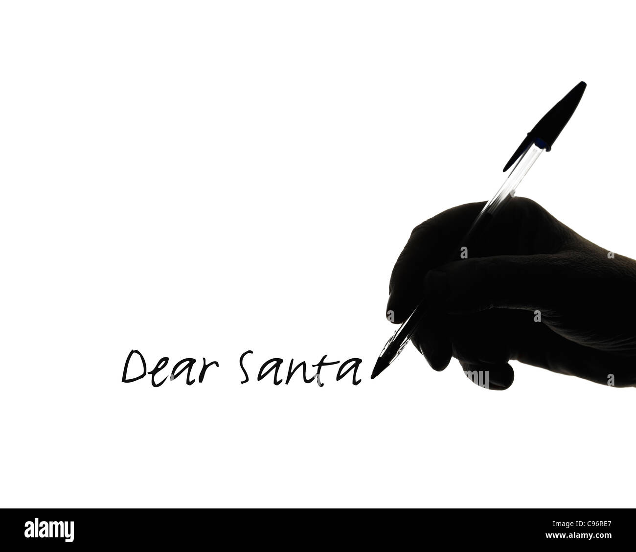 Hand holding a ballpoint pen writing Dear Santa on a white background ...