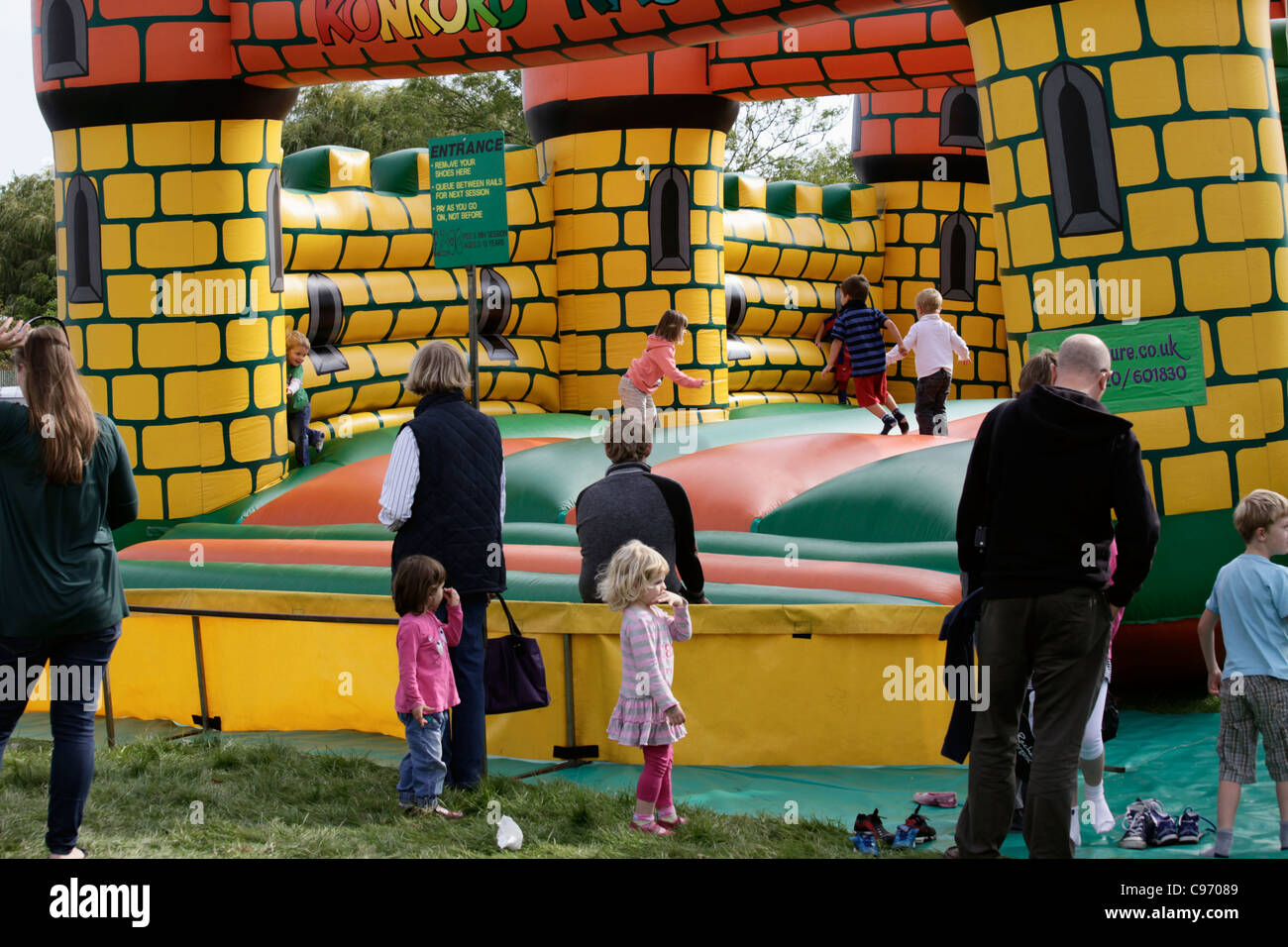 Parents and children at bouncy castle Stock Photo - Alamy