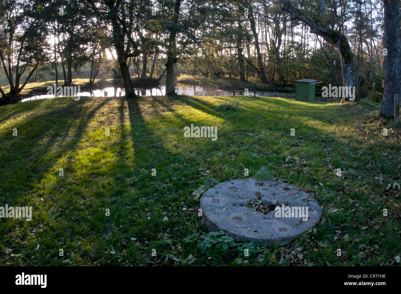 Old millstone by the river and the water mill Stock Photo - Alamy